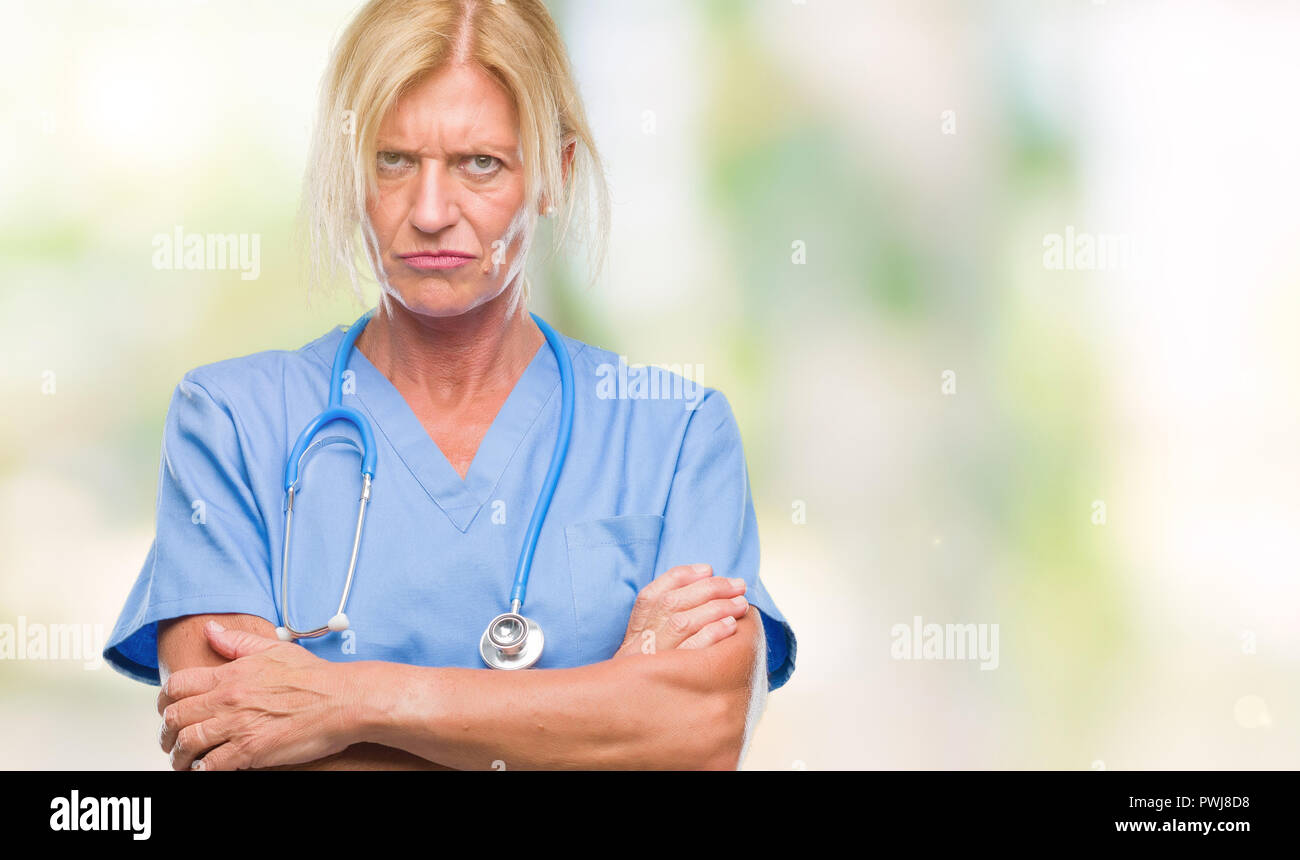 Middle age blonde nurse surgeon doctor woman over isolated background ...