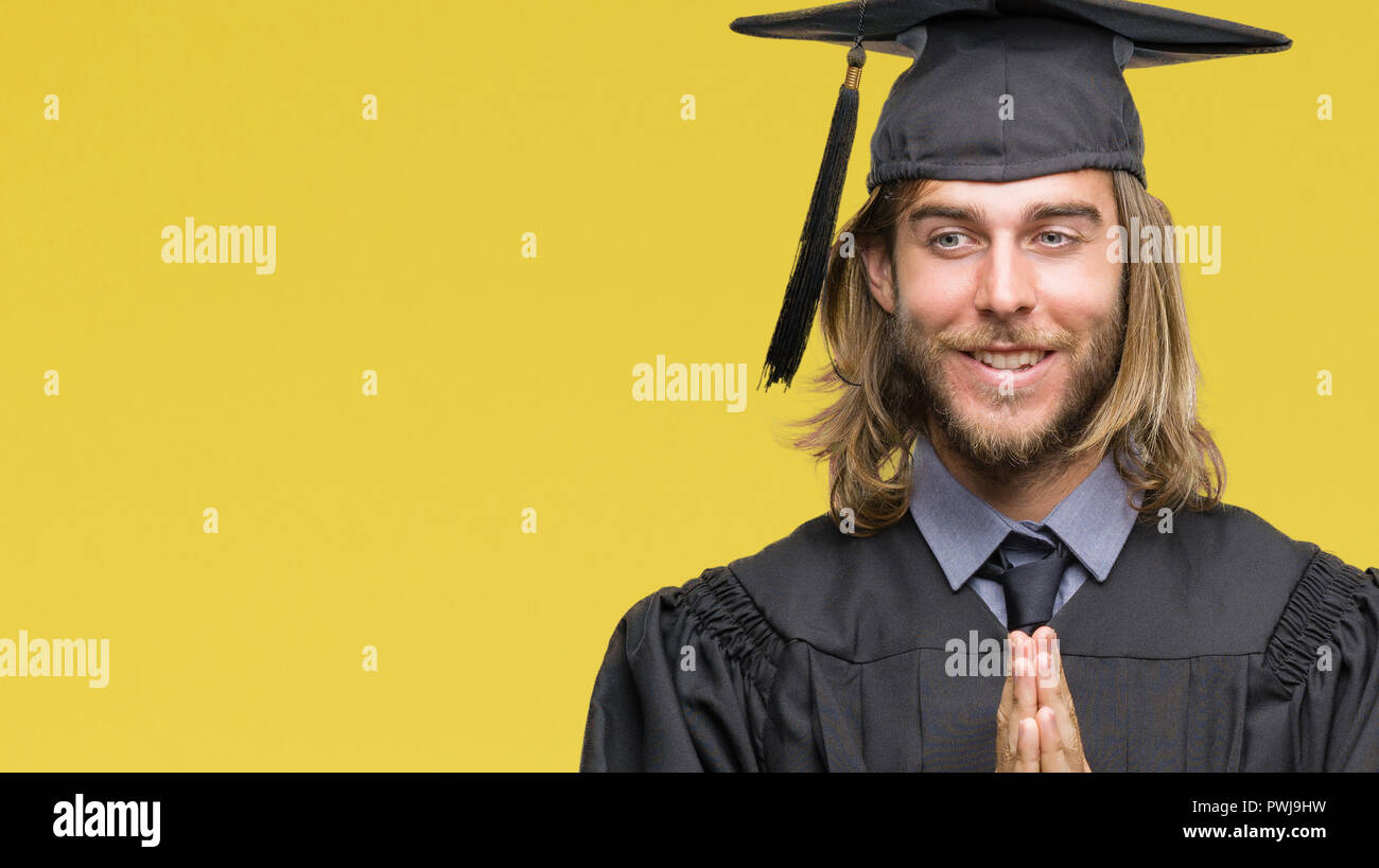 Young handsome graduated man with long hair over isolated background ...