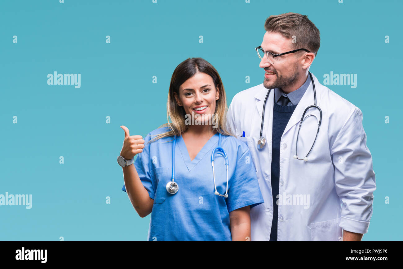 Young couple of doctor and surgeon over isolated background smiling ...