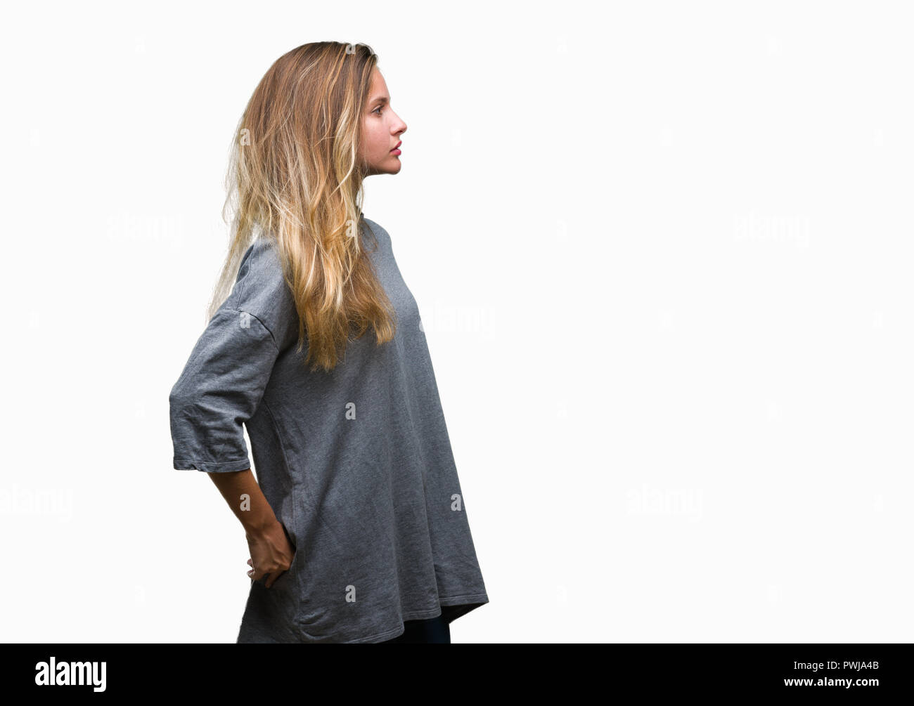 Young beautiful blonde woman over isolated background looking to side ...