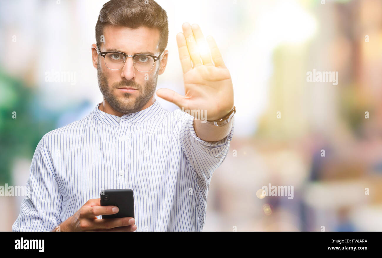 Young handsome man texting using smartphone over isolated background ...