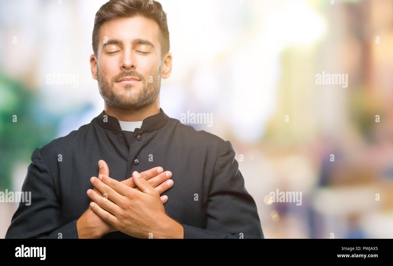 Young catholic christian priest man over isolated background smiling ...