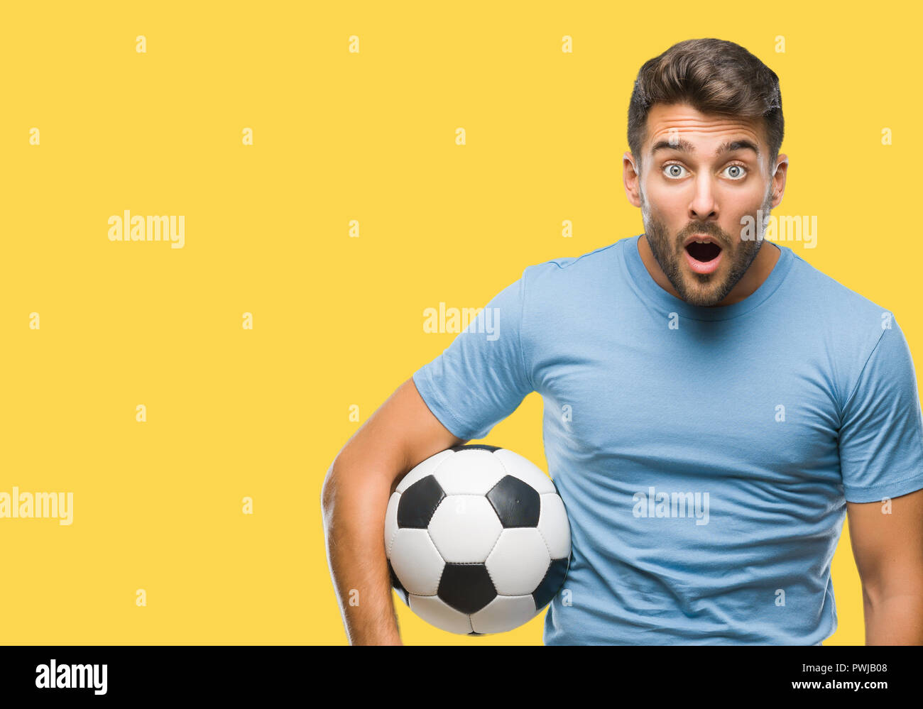 Young handsome man holding soccer football ball over isolated ...