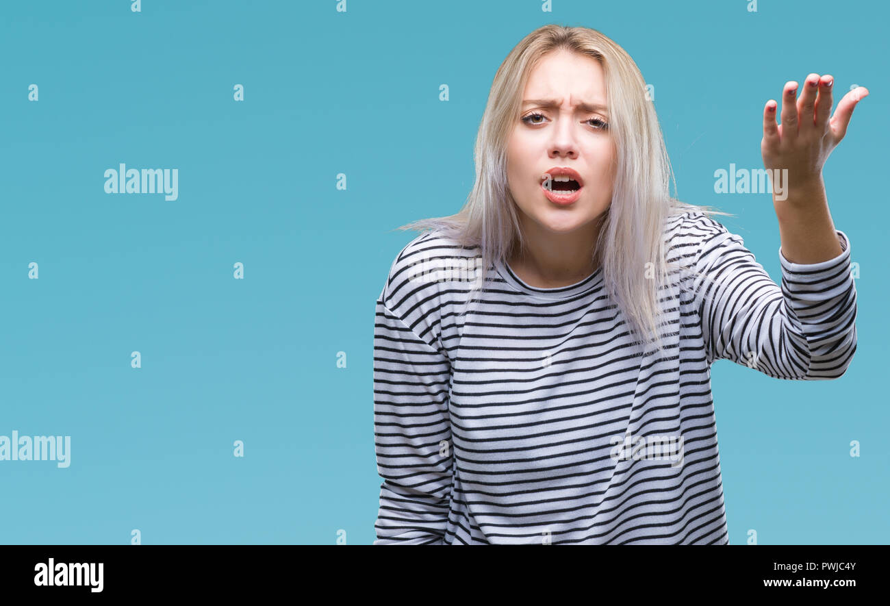 Young blonde woman over isolated background angry and mad raising fist ...
