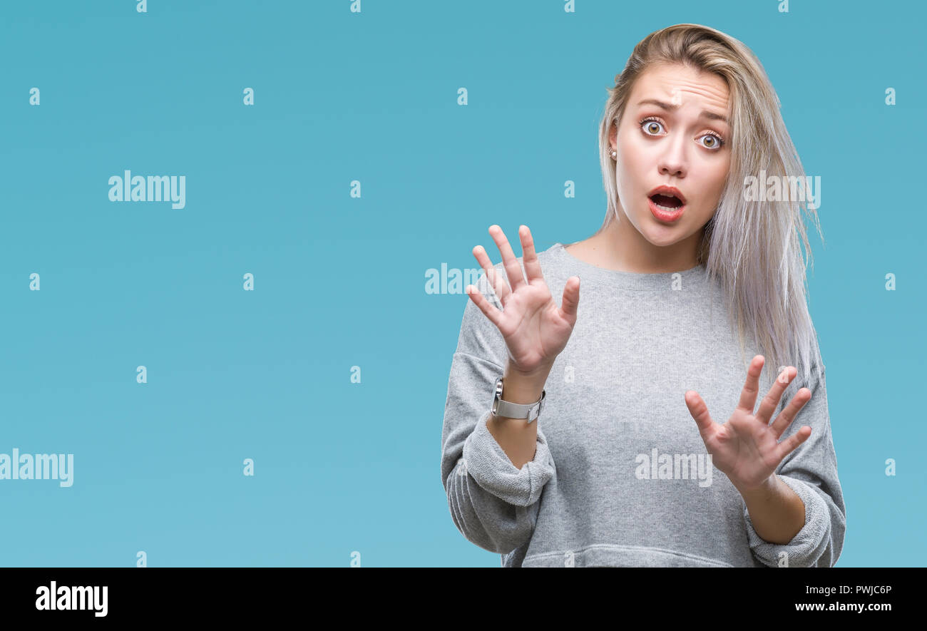 Young blonde woman over isolated background afraid and terrified with ...