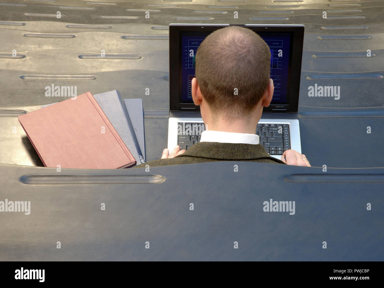 Student with laptop and books sitting in lecture hall Stock Photo - Alamy