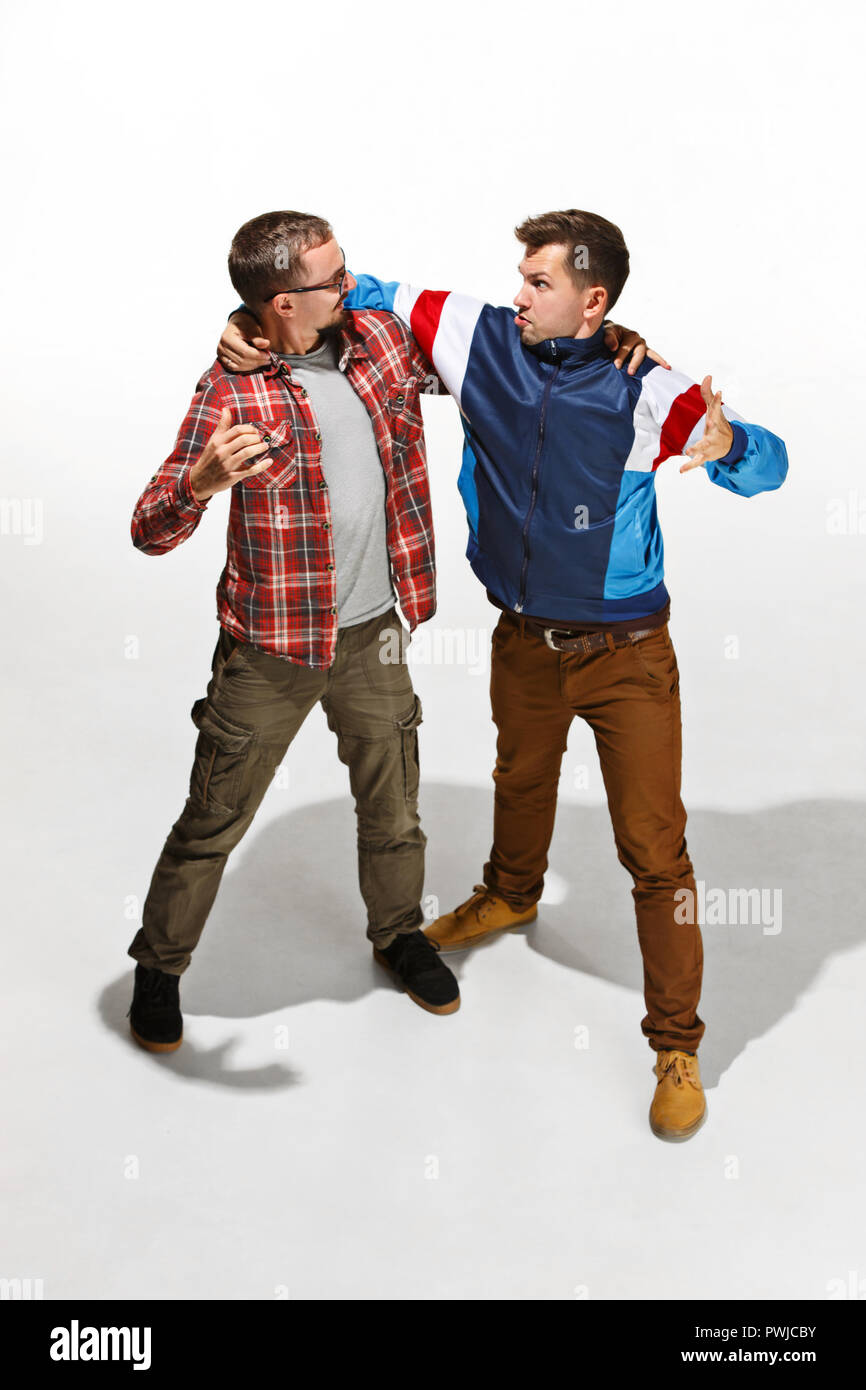 Two friends in casual colorful wear standing and laughing together ...