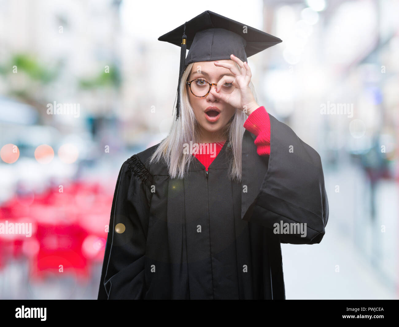 Young blonde woman wearing graduate uniform over isolated background ...