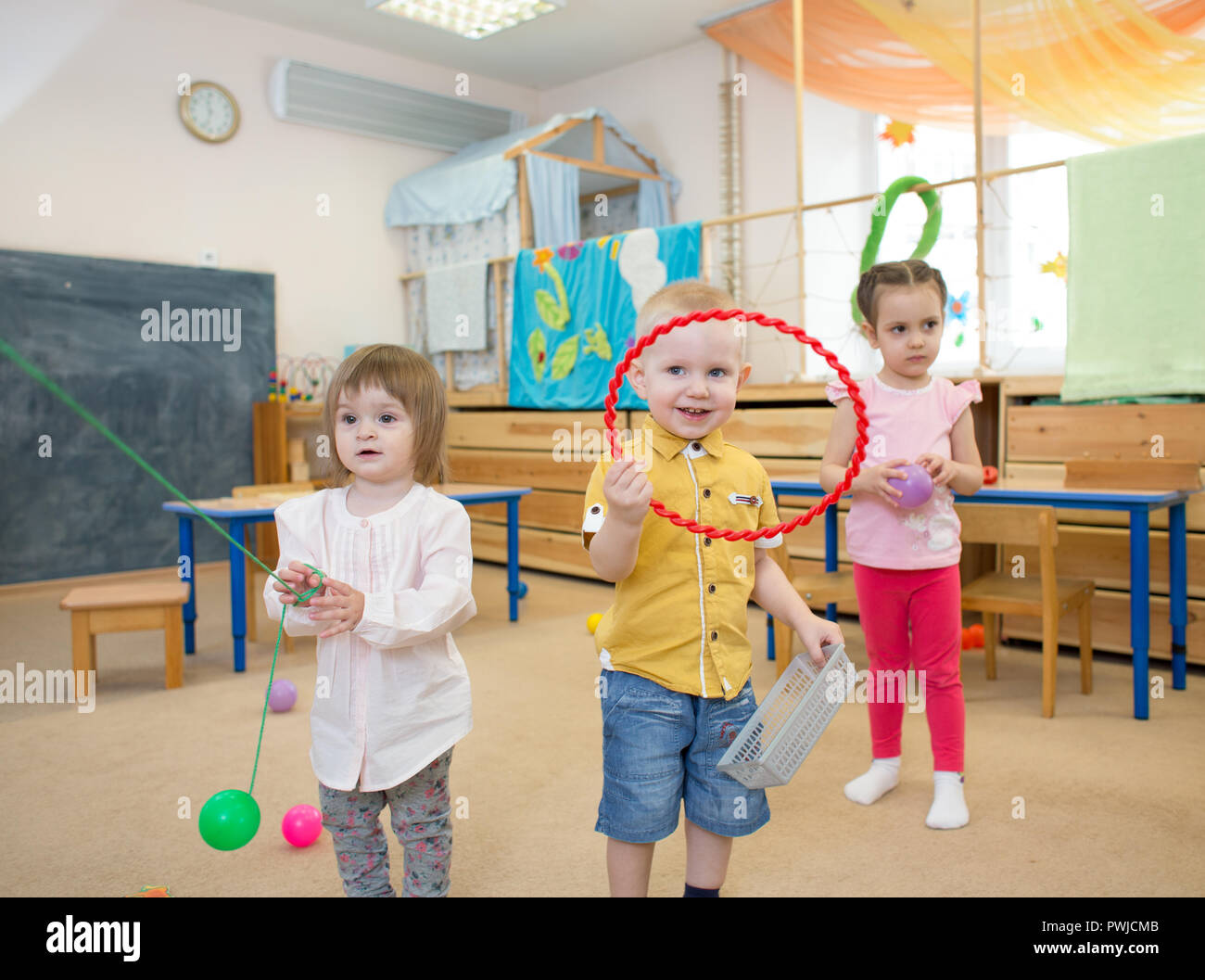 Group of children playing together in kindergarten or daycare centre ...