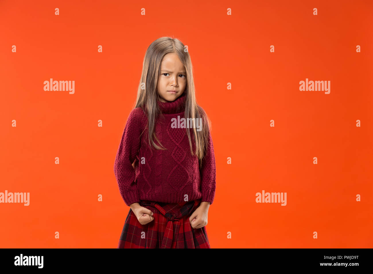 Angry teen girl standing on trendy studio background. Female half ...