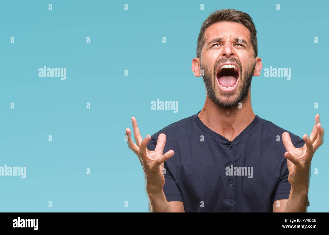 Young handsome man over isolated background crazy and mad shouting and ...