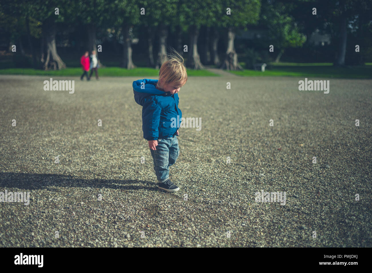 A little toddler is standing outside in a courtyard Stock Photo - Alamy