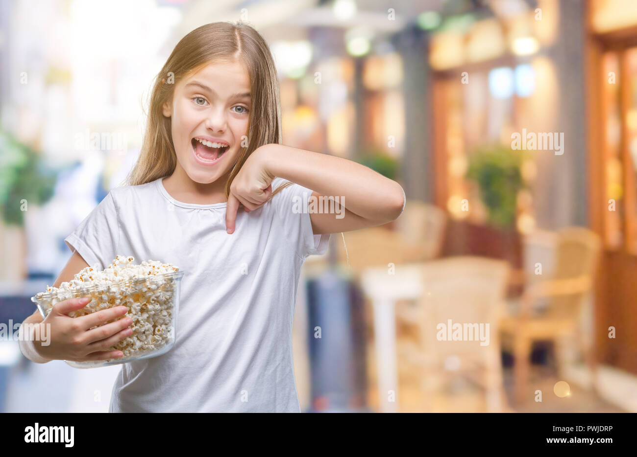 Young beautiful girl eating popcorn snack isolated background with ...