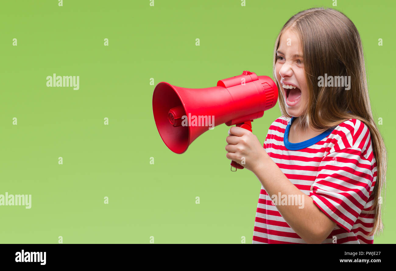 Young beautiful girl yelling through megaphone over isolated background ...