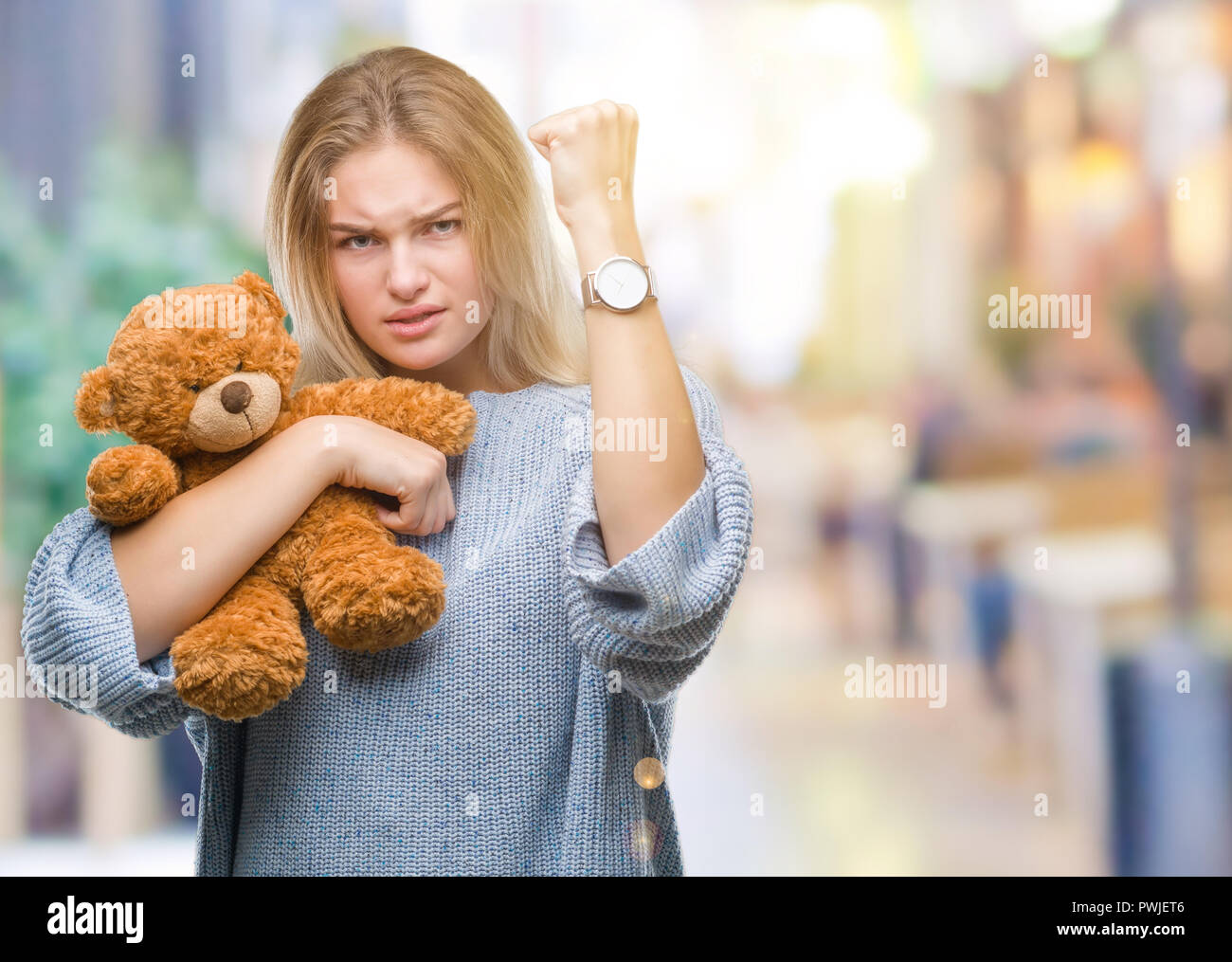 Young caucasian woman holding cute teddy bear over isolated background ...