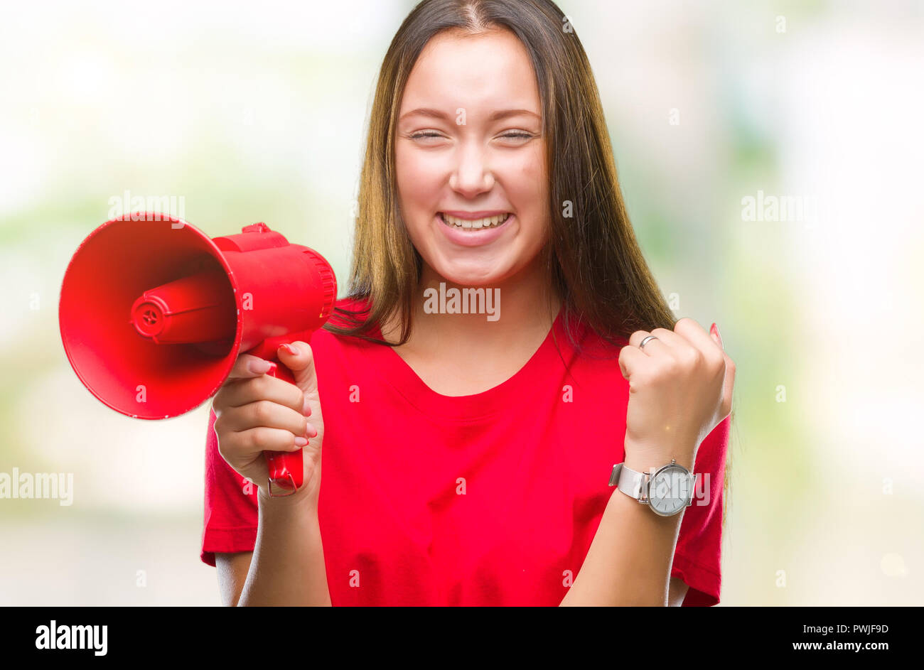 Young caucasian woman yelling through megaphone over isolated ...