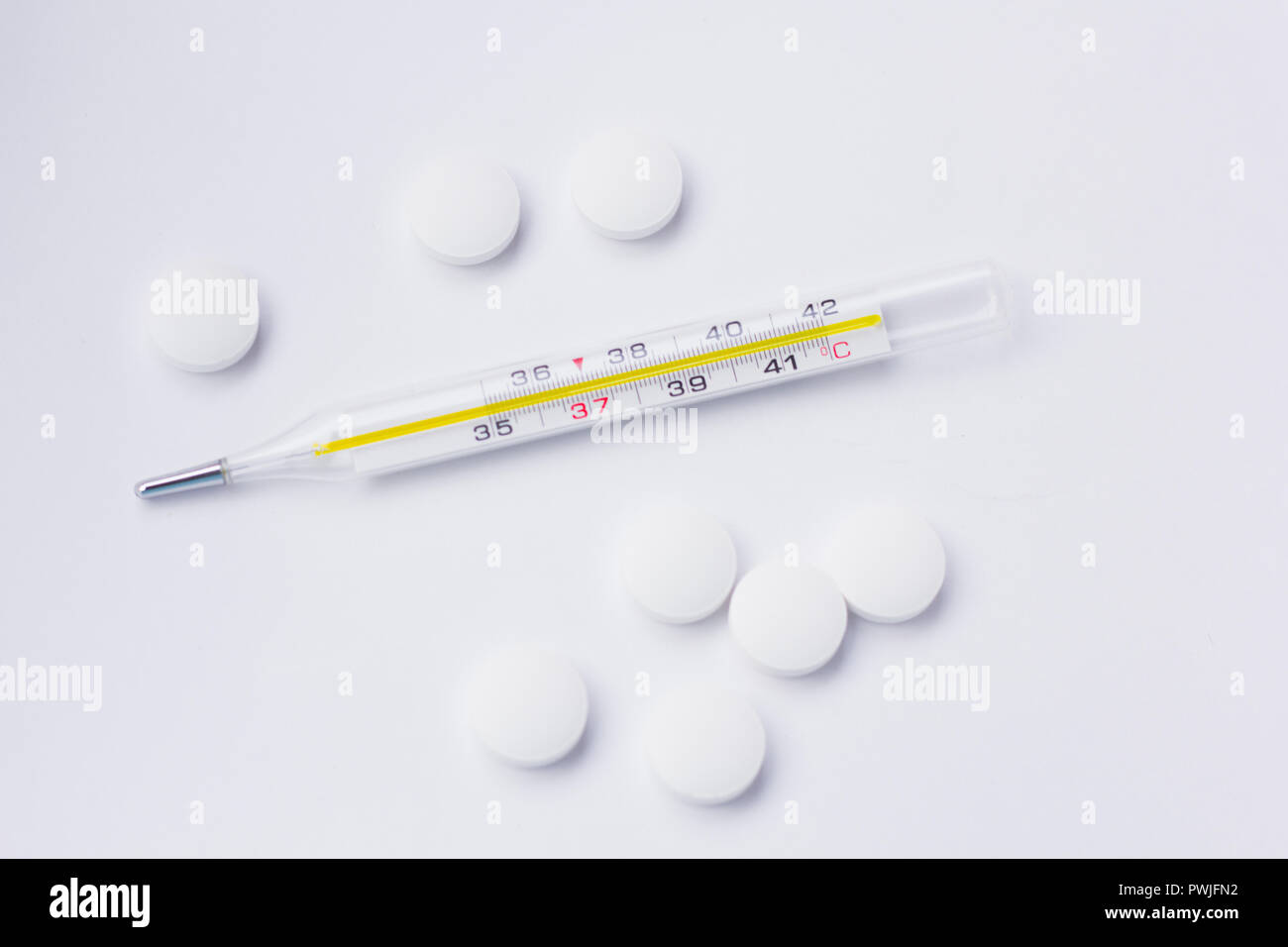 pill and thermometer on a white background. A cure for pain. Health and ...