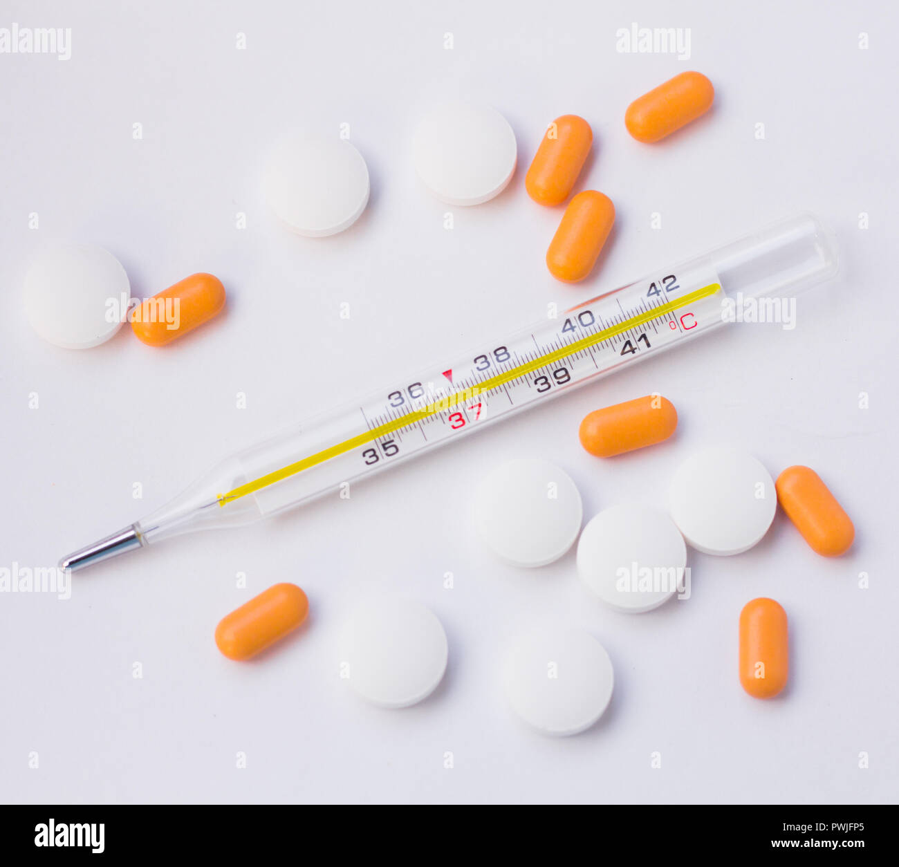 pill and thermometer on a white background. A cure for pain. Health and ...