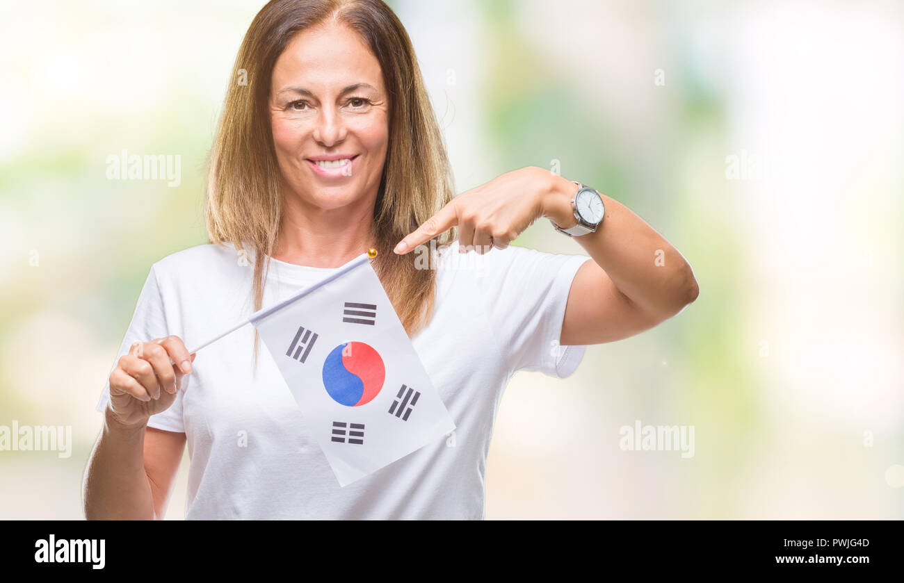 Middle age hispanic woman holding flag of South Korea over isolated ...