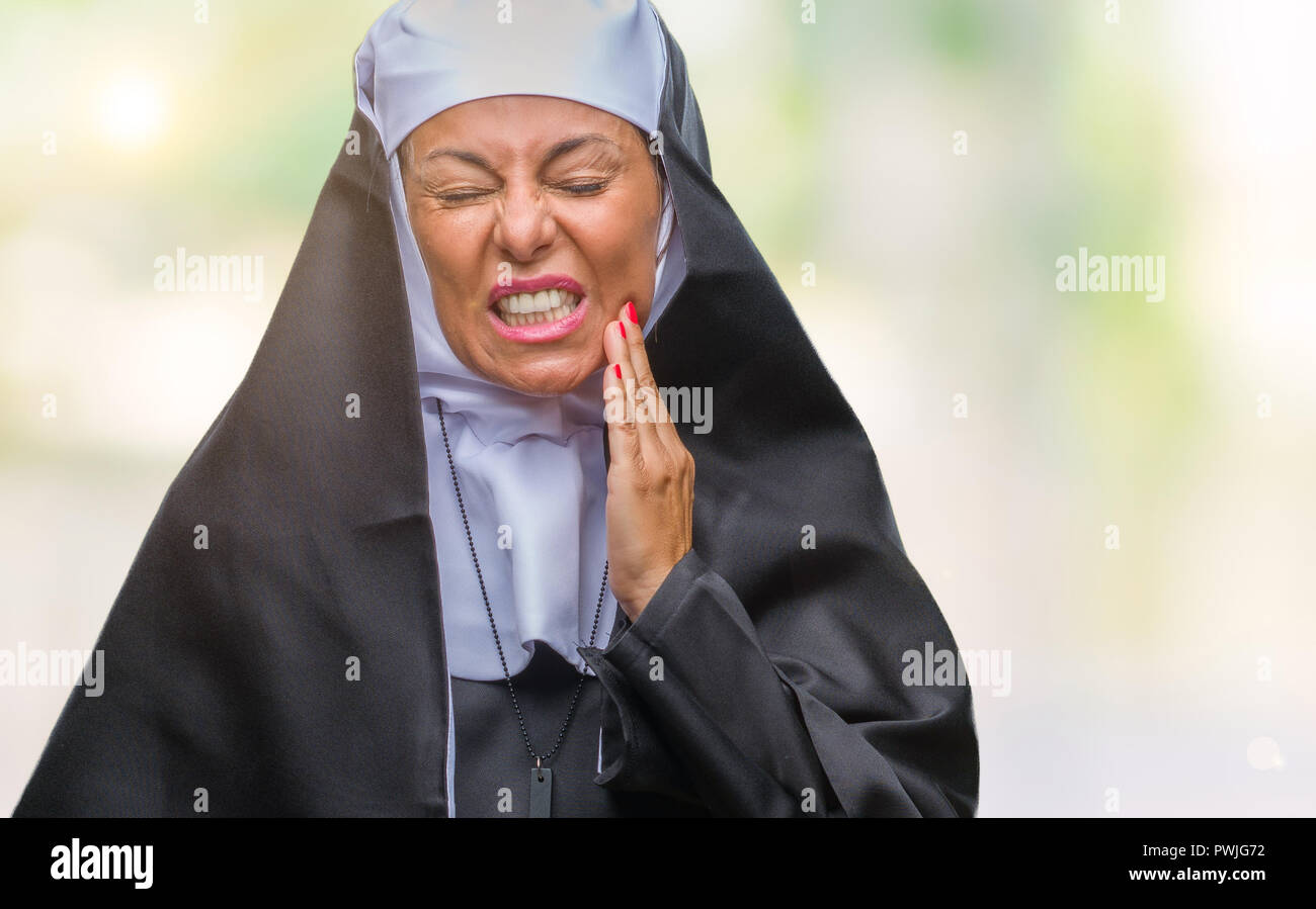 Middle age senior christian catholic nun woman over isolated background ...