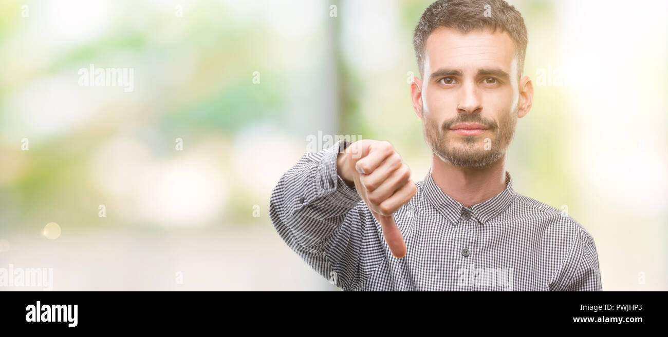 Young hipster man looking unhappy and angry showing rejection and ...