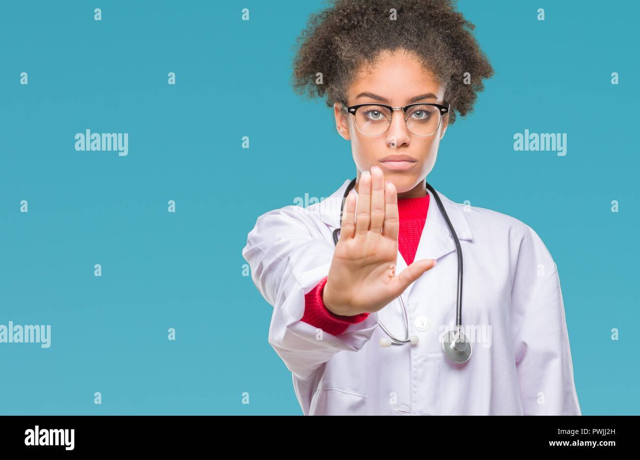 Young afro american doctor woman over isolated background doing stop ...