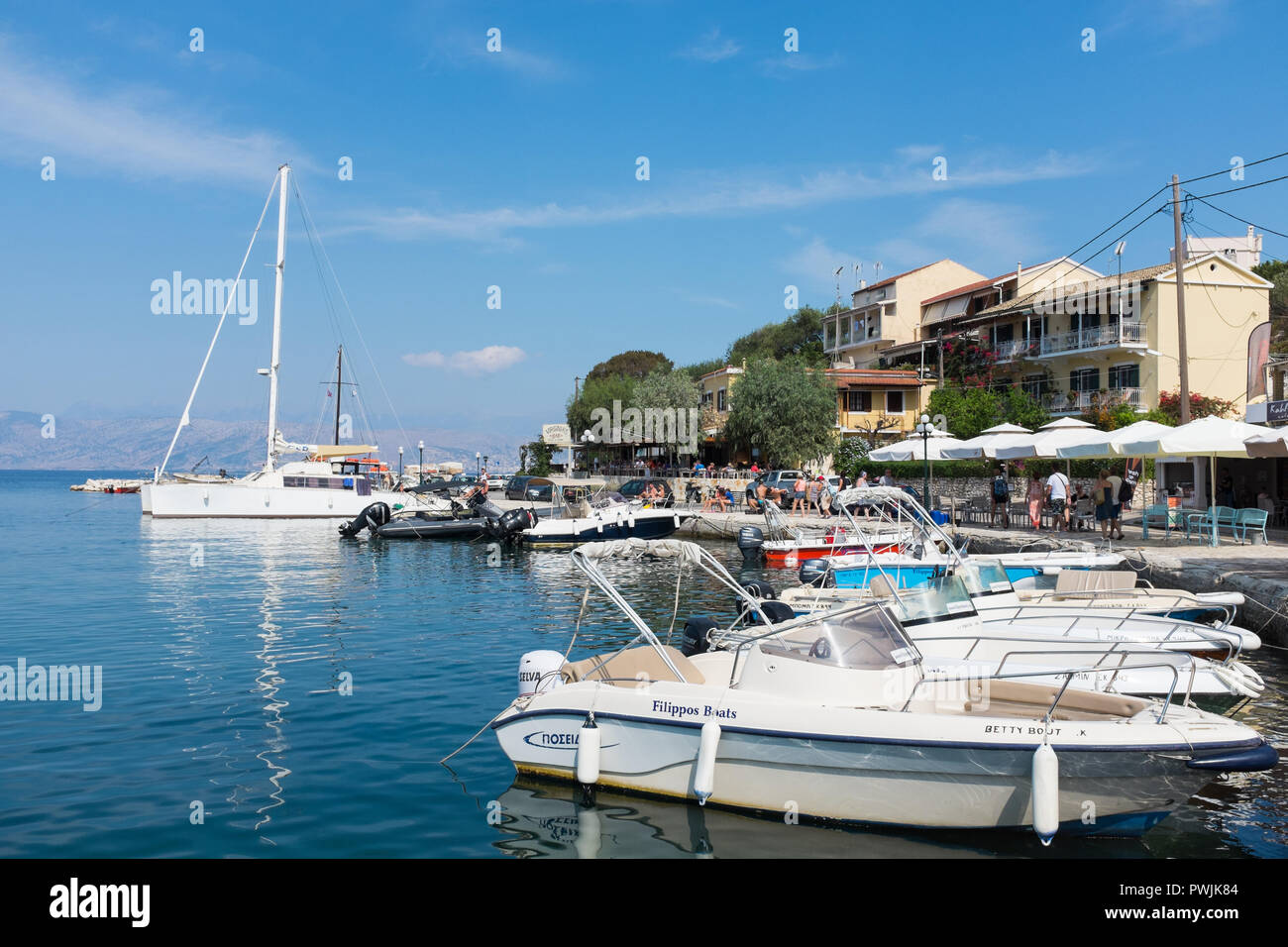 Boats moored at the picturesque harbour at Kassiopi in north east Corfu ...