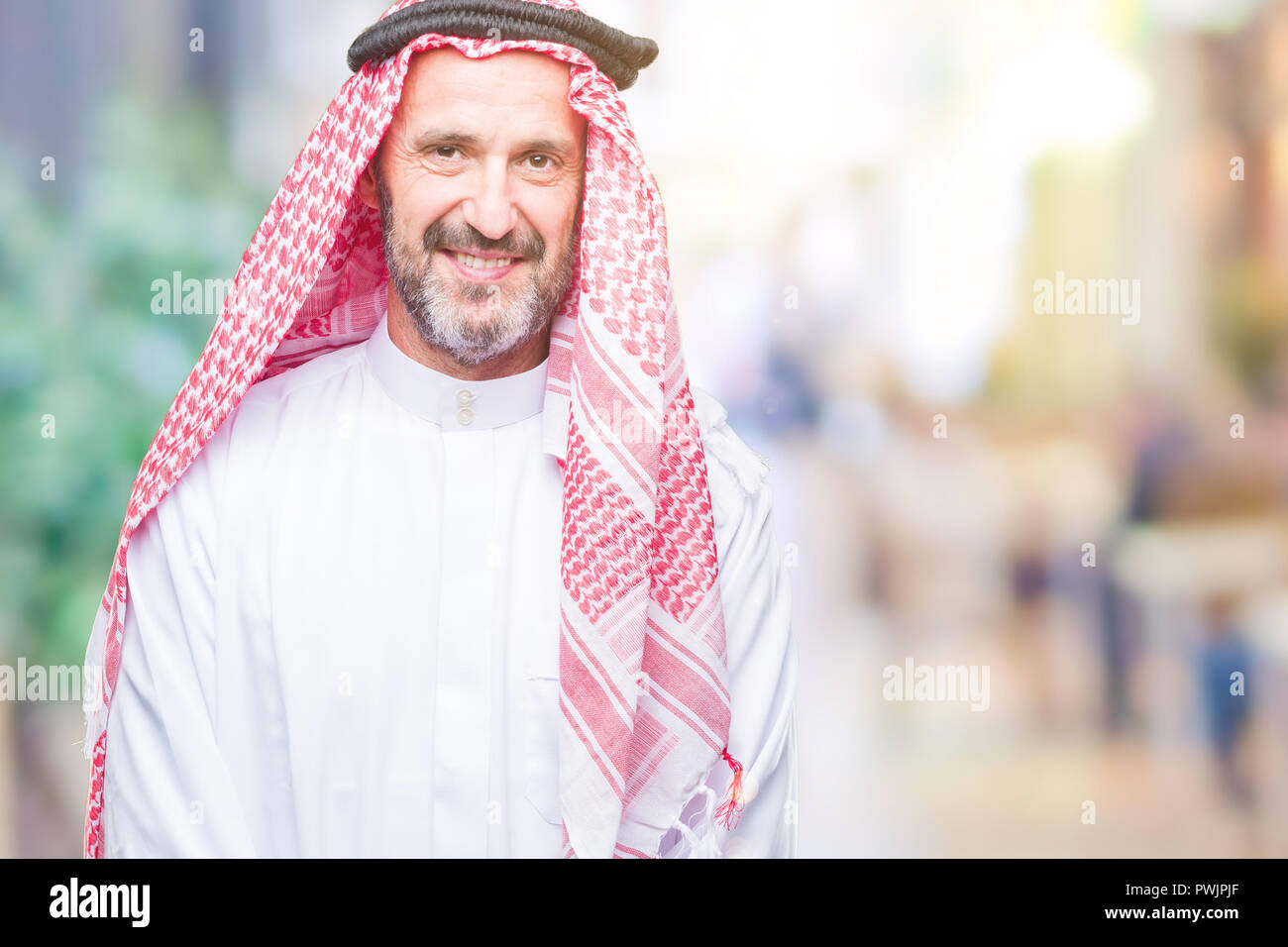 Senior arab man wearing keffiyeh over isolated background with a happy ...