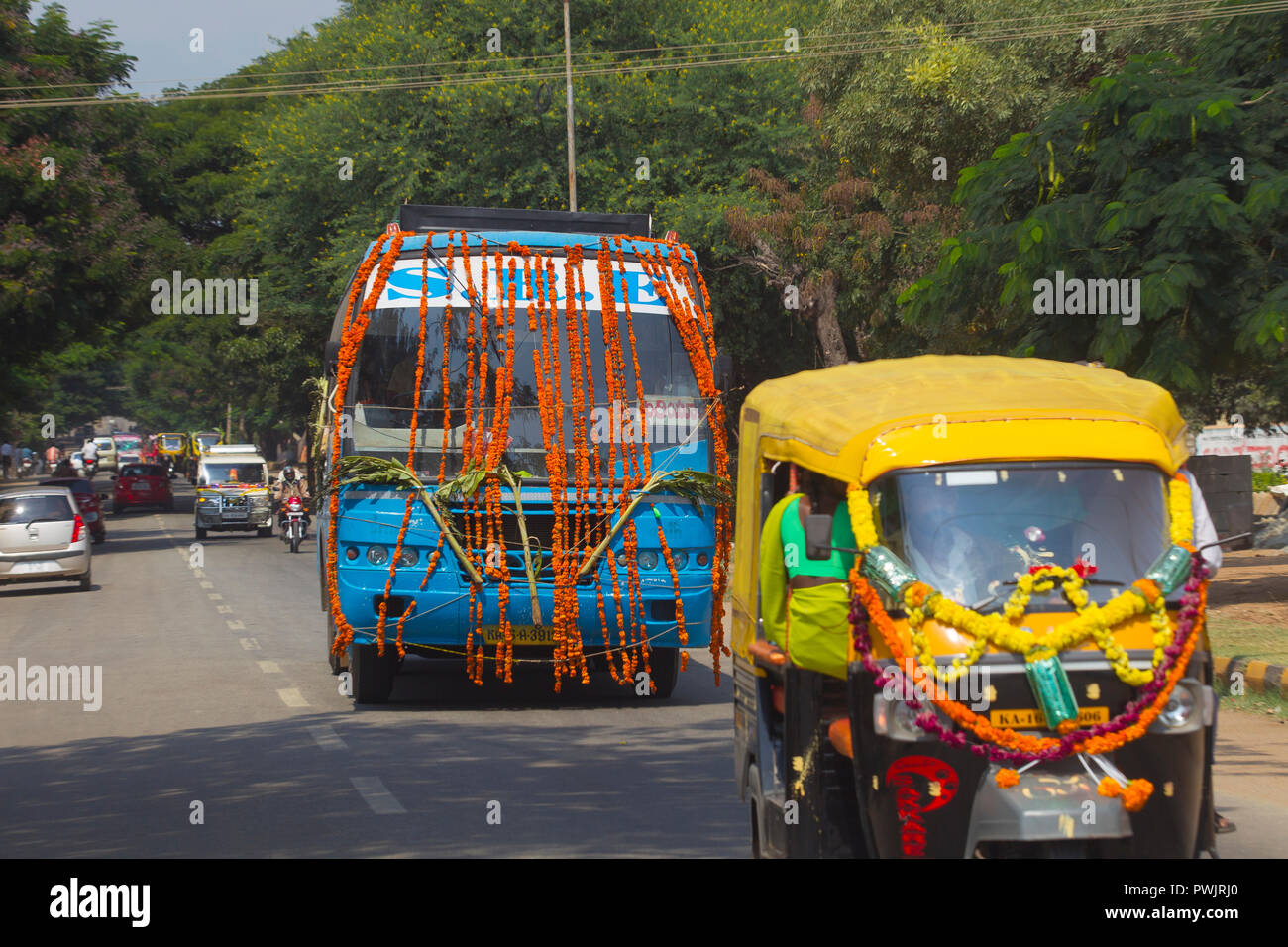 Typical tuk-tuk and bus decorated with flowers, Karnataka, India Stock ...