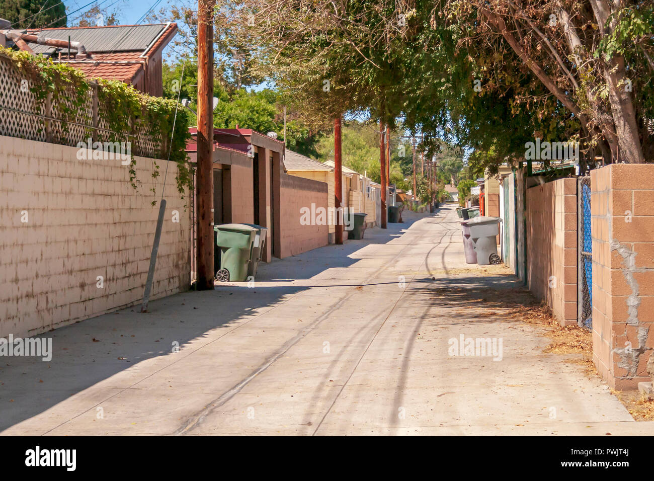 Narrow back alley with green garbage bins Stock Photo - Alamy
