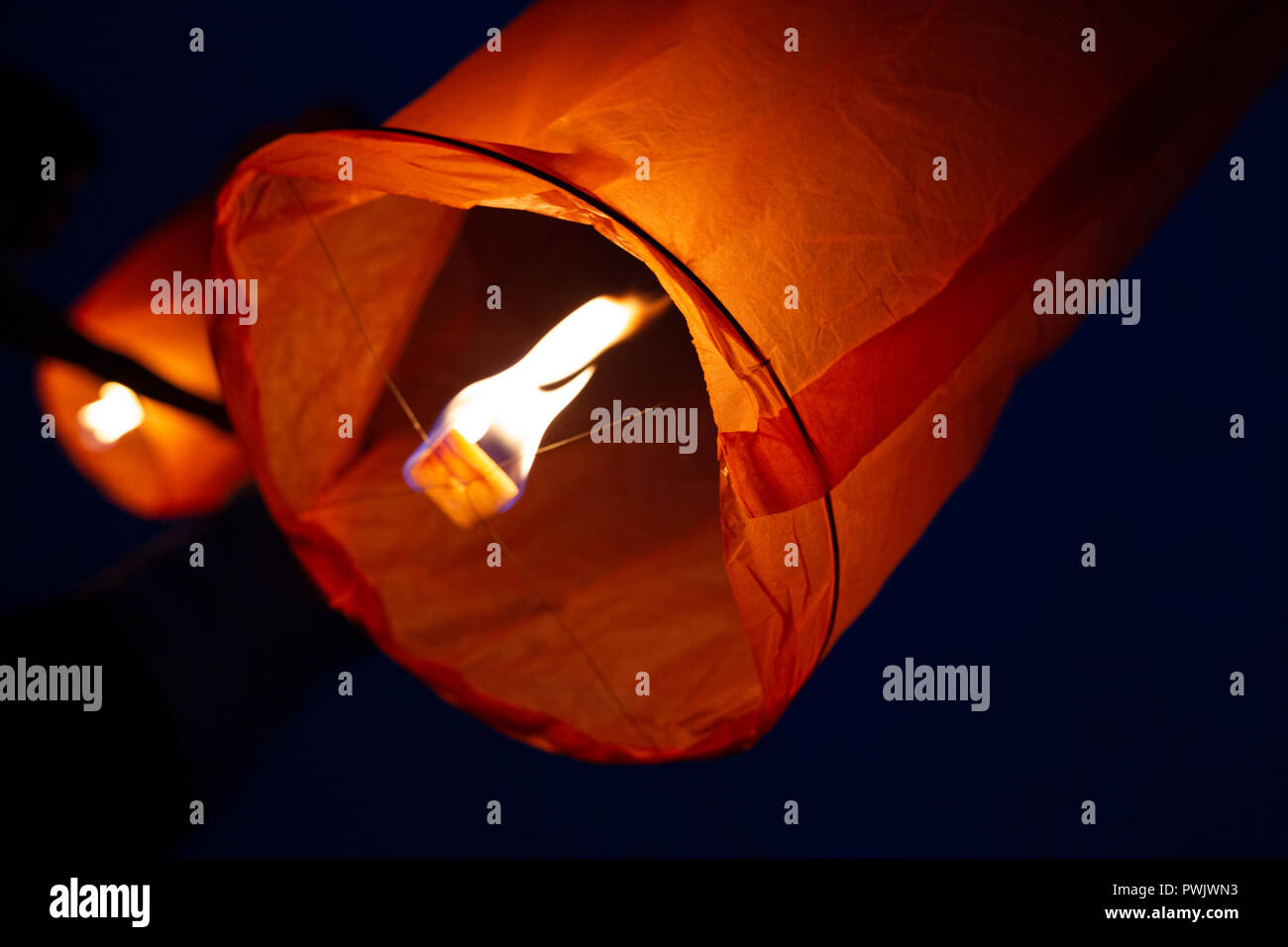 Close up view of two chinese flying lanterns with burning fire inside ...