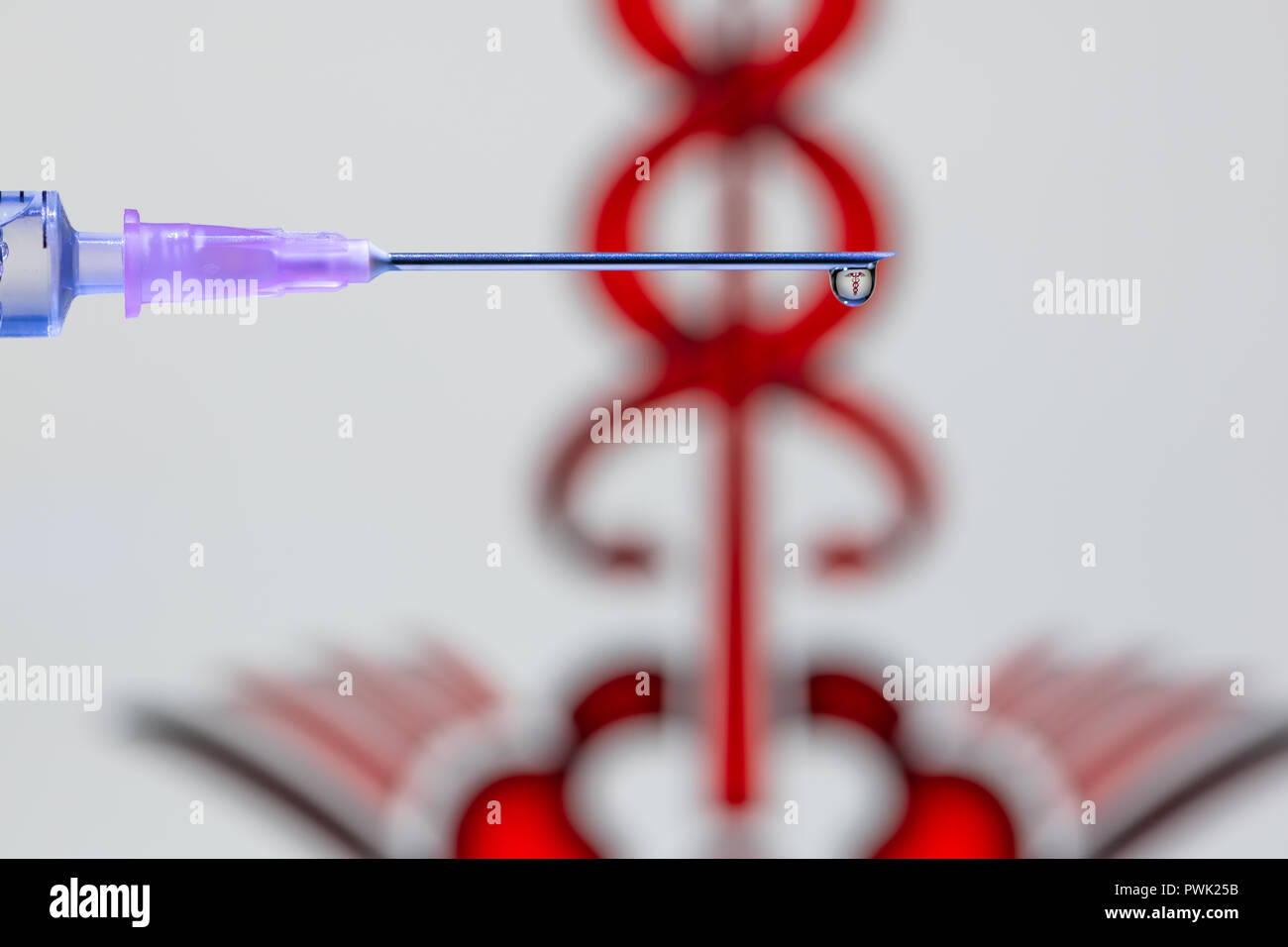 A droplet of vaccine at the tip of the needle and syringe reflecting ...