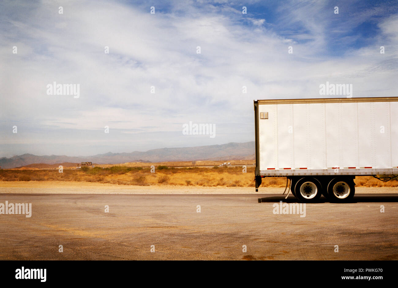 Trailer of a truck driving along a remote country road in the desert ...