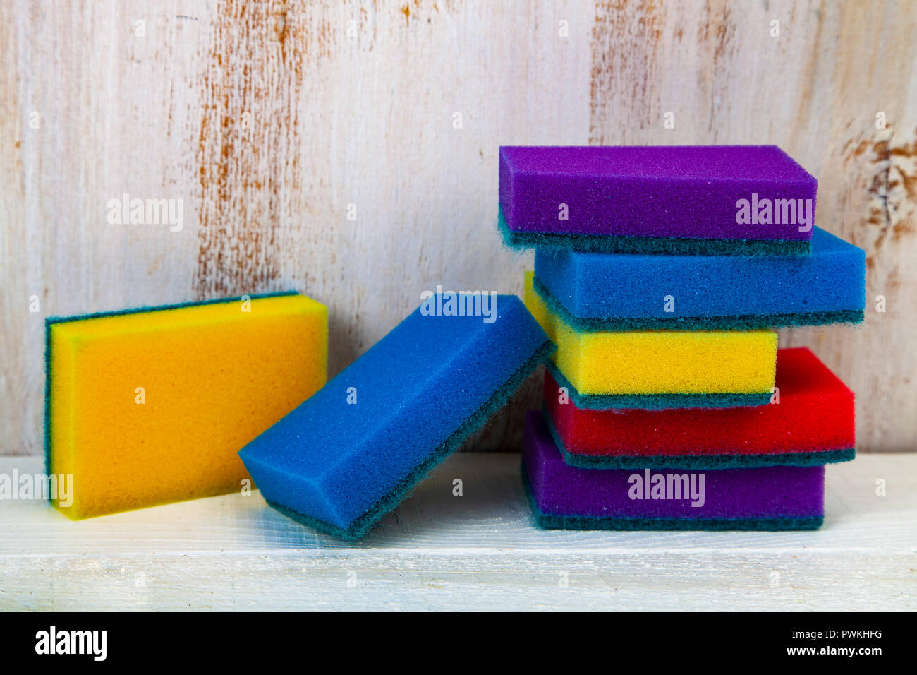 Multi-colored sponges for washing dishes on a wooden background Stock ...