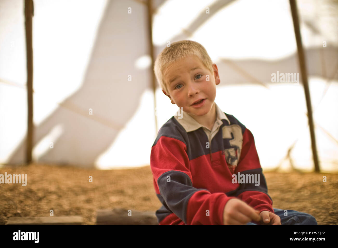 Portrait of a young boy making a face while sitting outside Stock Photo ...