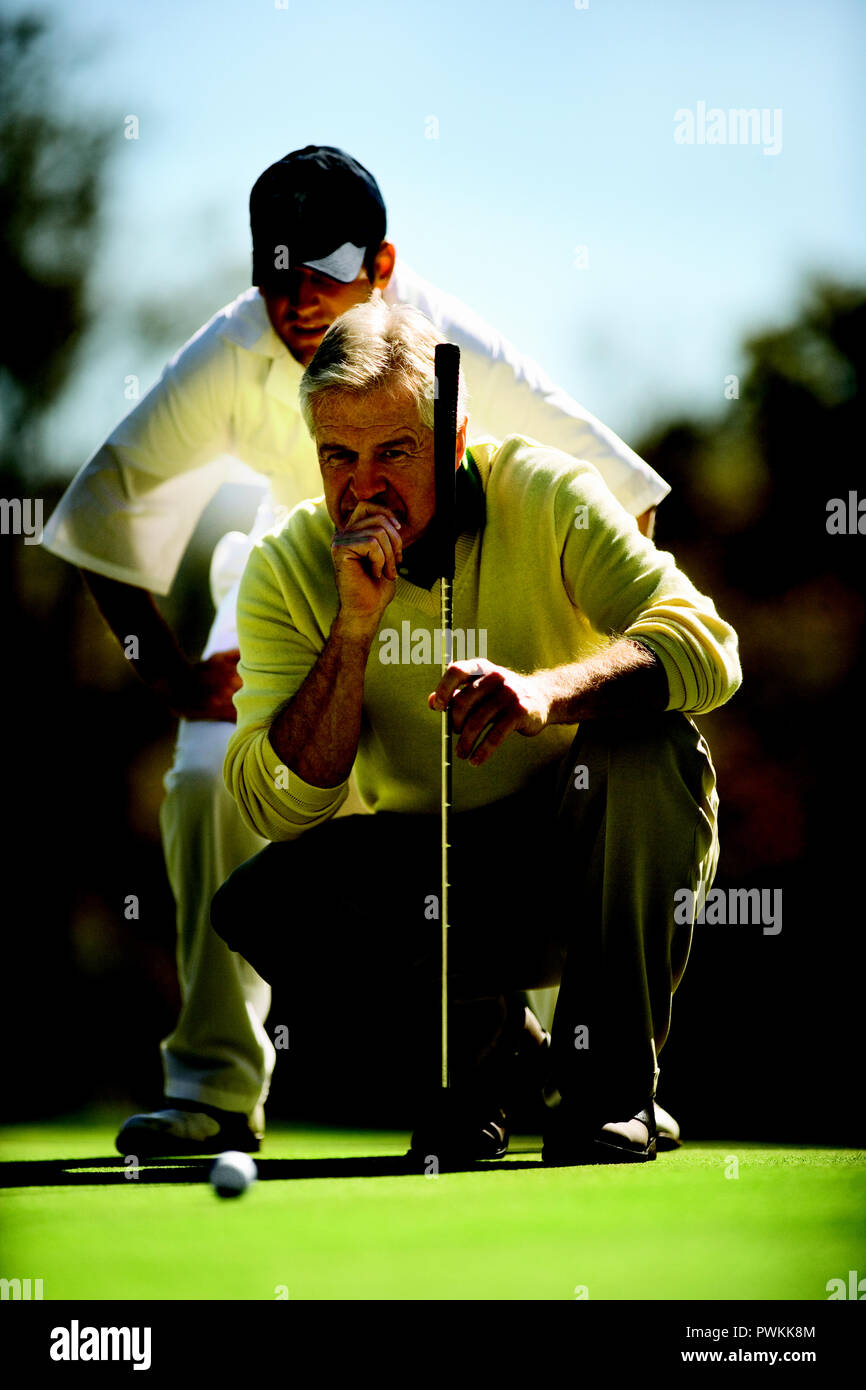 Front view of two golfers intently watching a golf ball Stock Photo - Alamy