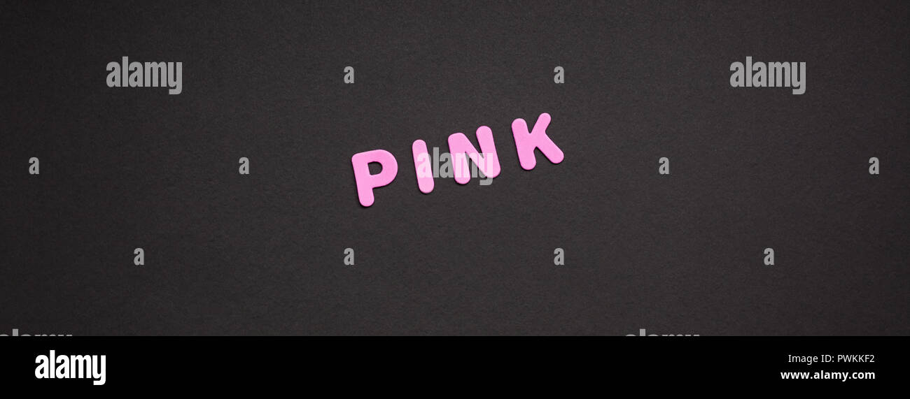 Creative colorful text made from plastic letters pink writing on black ...