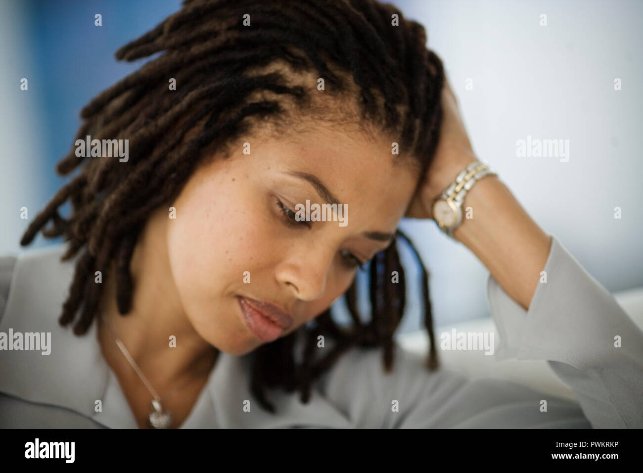 Serious mid-adult woman leaning her head on her hand Stock Photo - Alamy