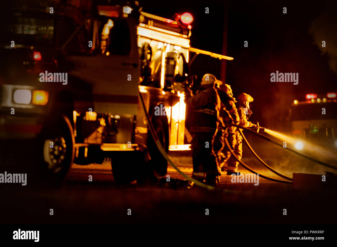 Group of fireman putting out a fire Stock Photo - Alamy