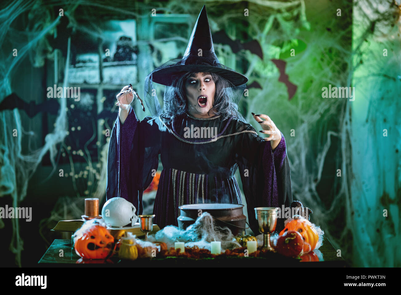Witch with awfully face in creepy surroundings full of cobweb sends ...
