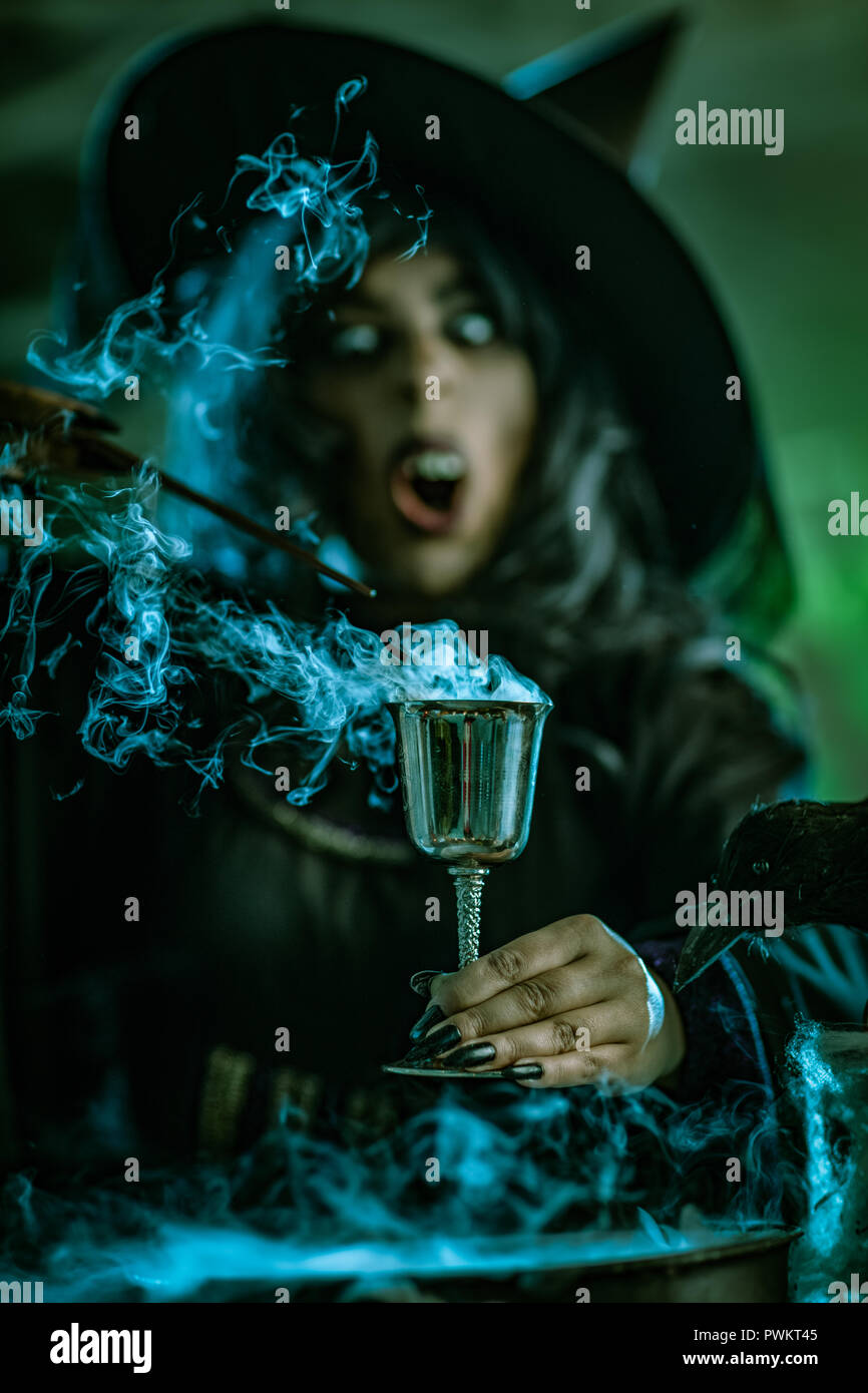 Portrait of witch with awfully face in creepy surroundings and smoky ...