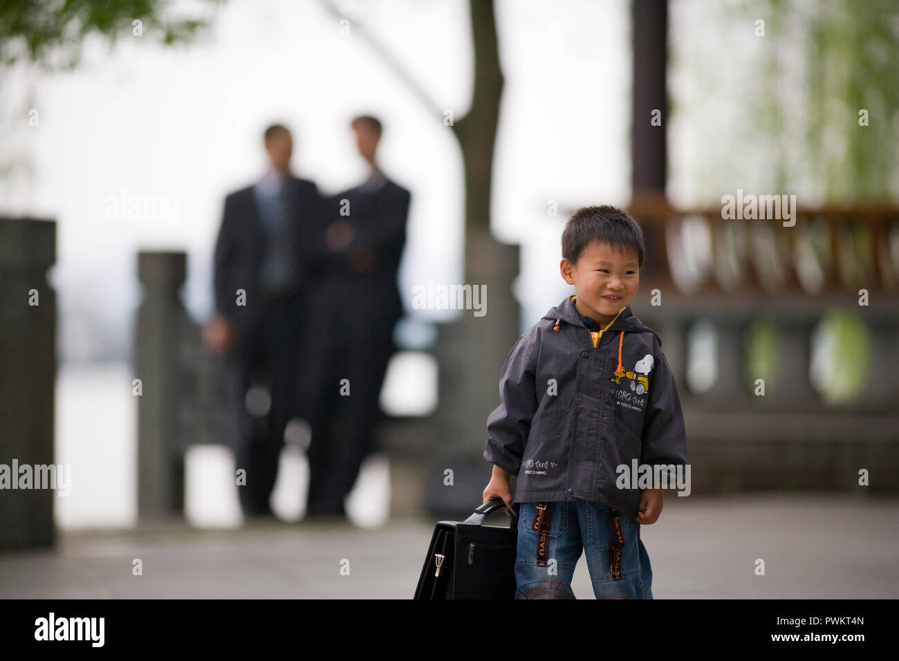 Smiling young boy carrying a suitcase Stock Photo - Alamy