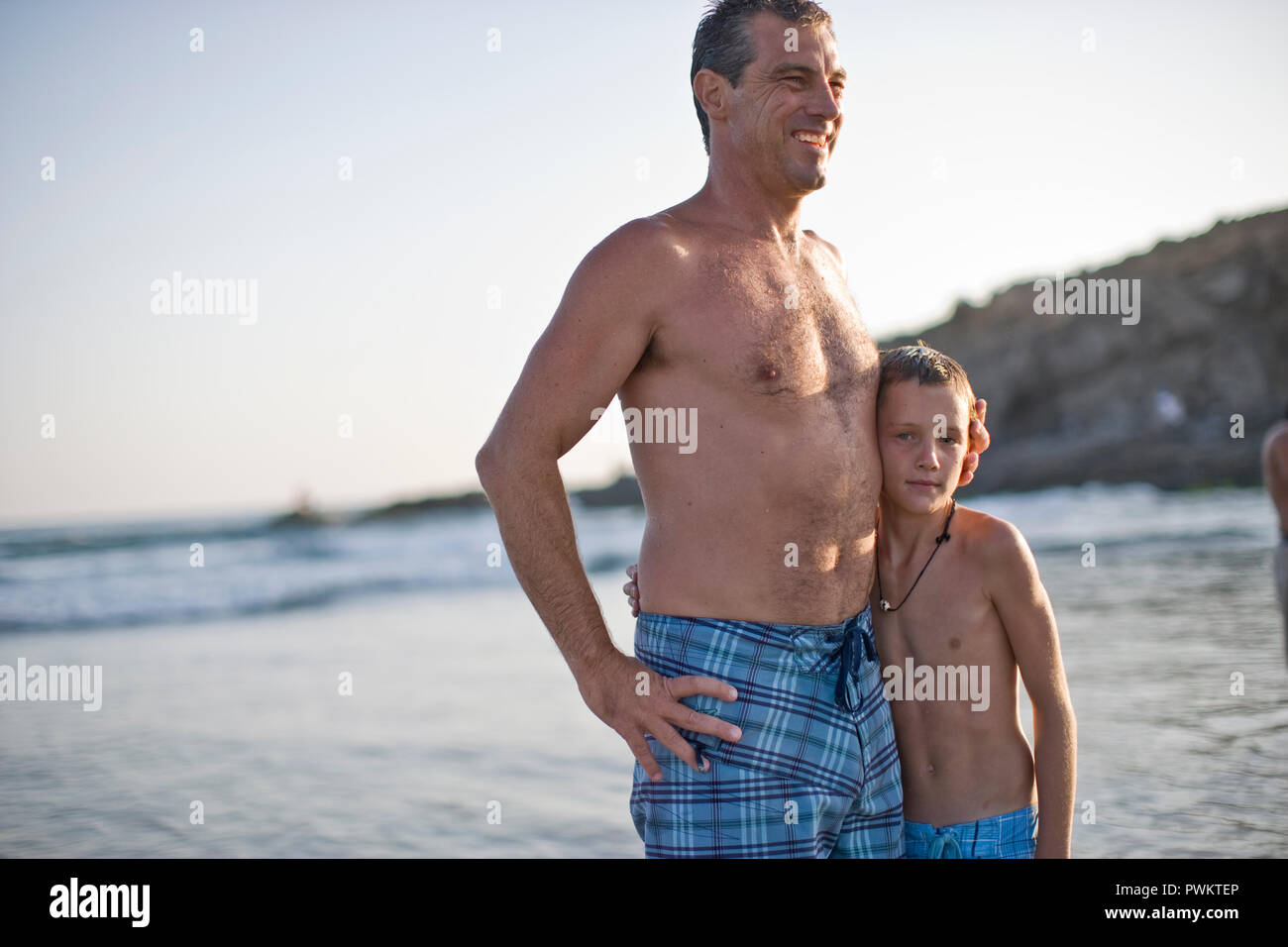 Father and son standing together at the beach Stock Photo - Alamy