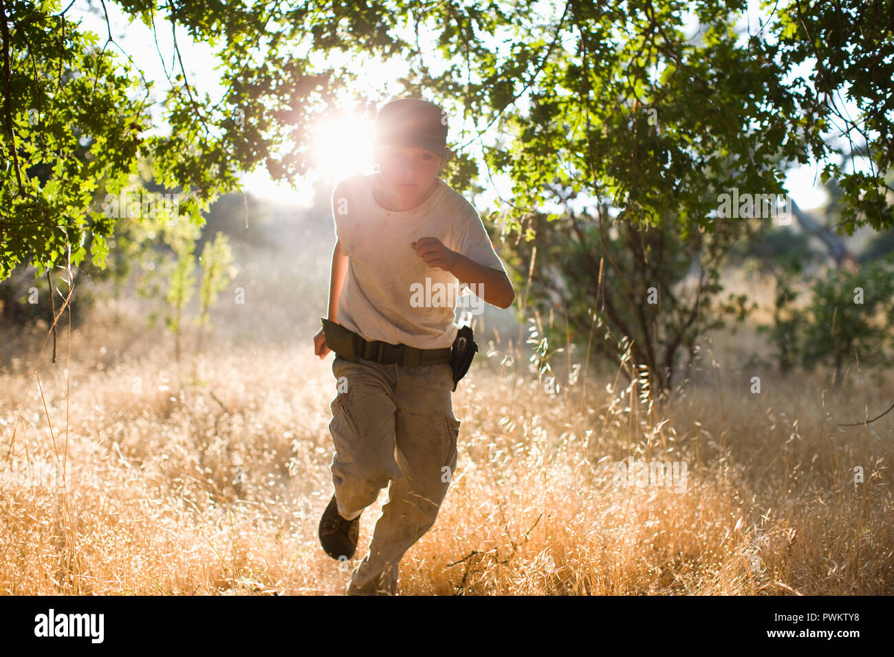 Boy running through trees Stock Photo - Alamy