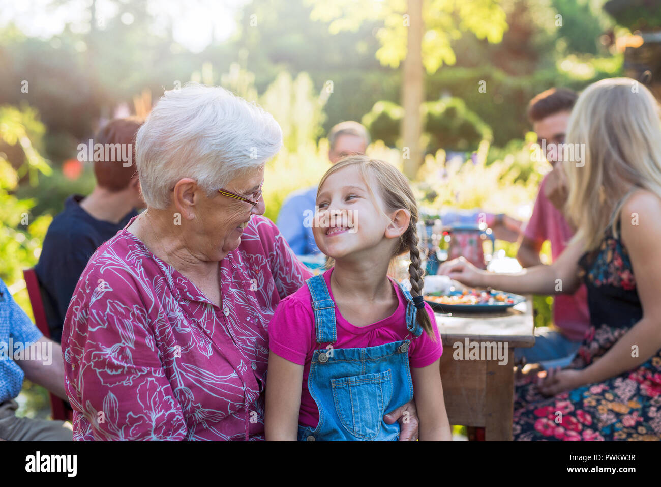 Summertime , a family of three generations having fun around a table in ...