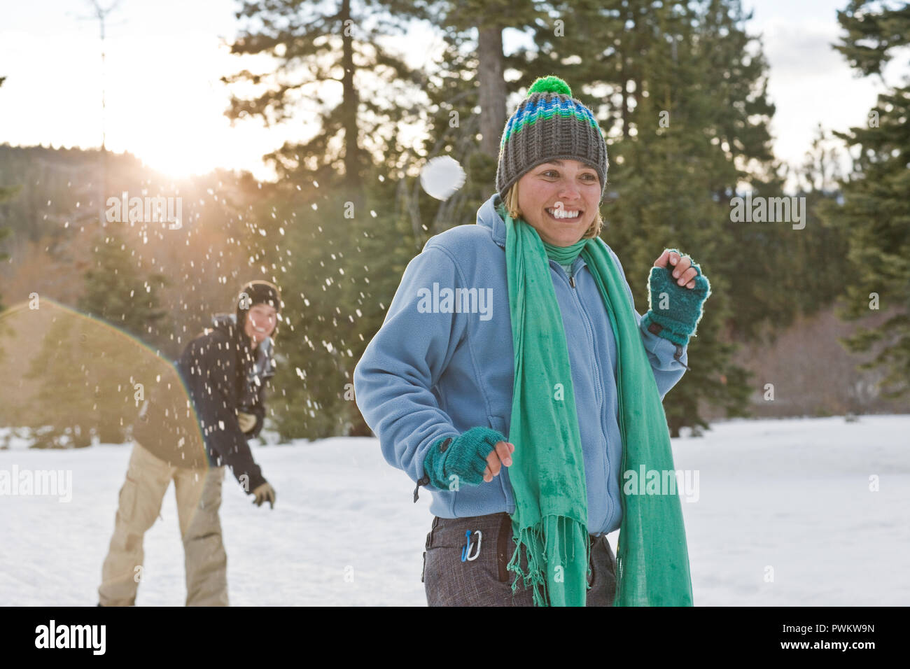 Man throwing a snowball at a woman Stock Photo - Alamy