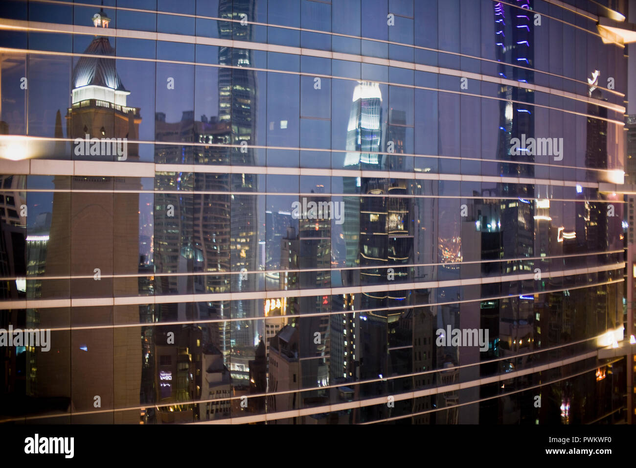 Illuminated skyline reflected on an inner city glass building at night ...