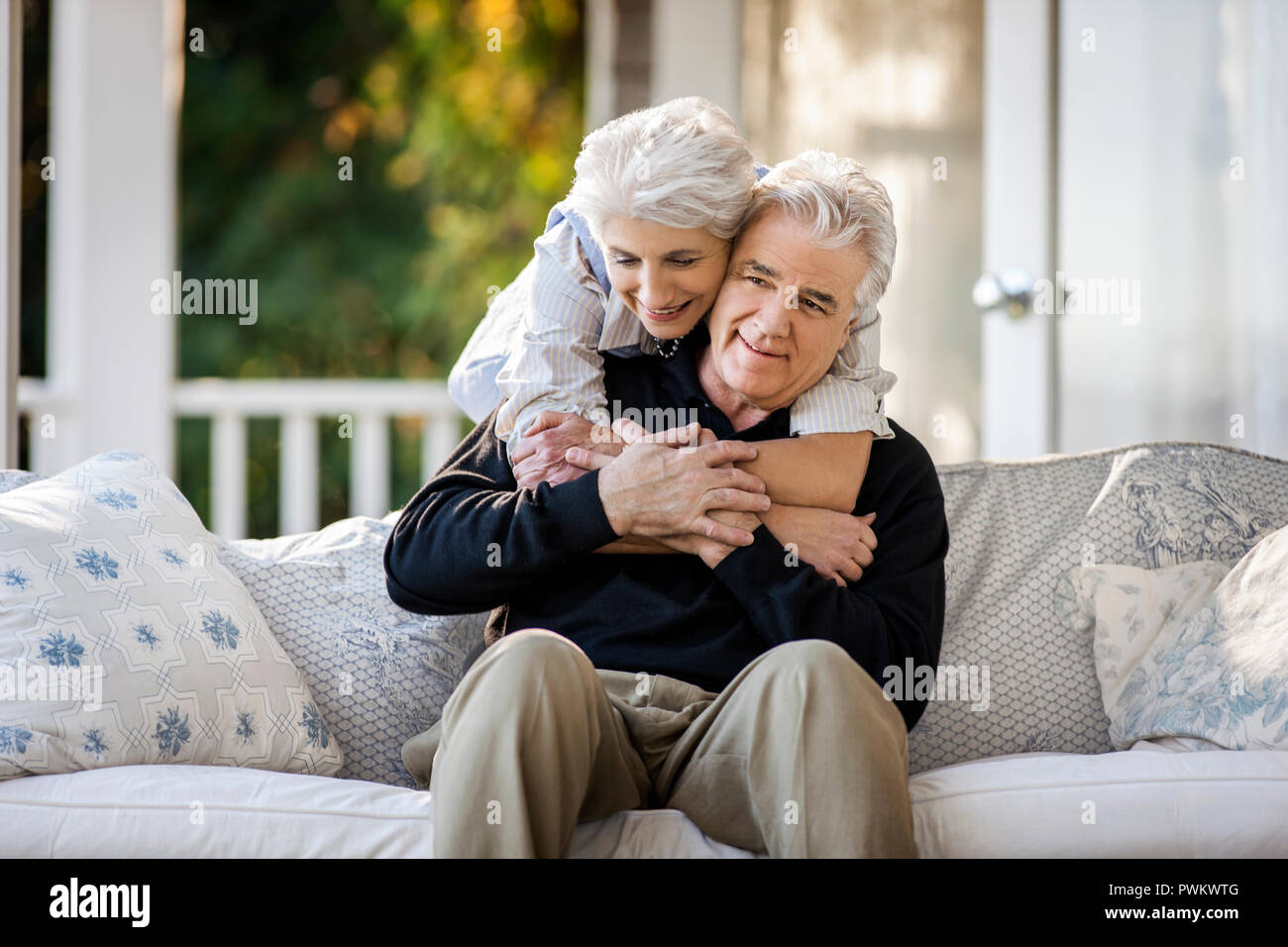 Mature couple embracing on their front porch Stock Photo - Alamy