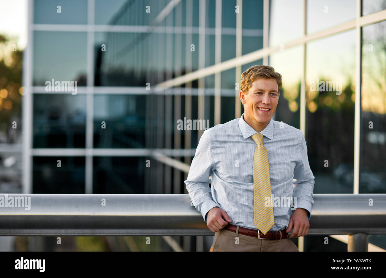 Young businessman standing on an office building Stock Photo - Alamy