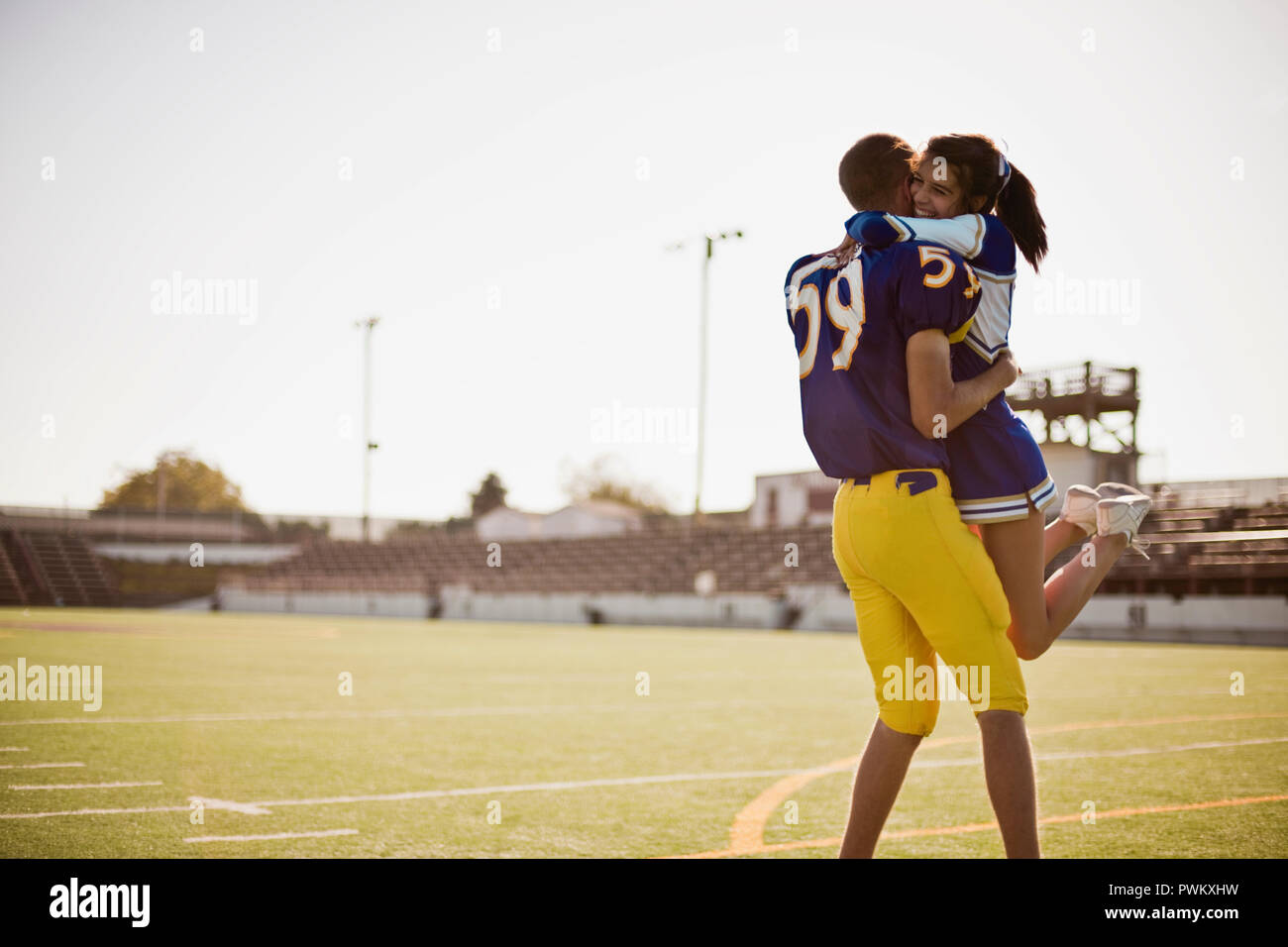 Football player picking up cheerleader in a lover's embrace Stock Photo ...